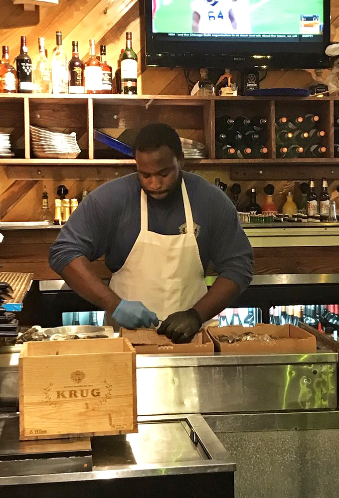 Fresh oysters being shucked with practiced precision. Those hands know exactly what they're doing&mdash;creating little oceanic miracles one shell at a time.