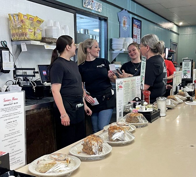 The staff shares laughs behind the counter while pies wait patiently—this is the heart of hospitality that chain restaurants try desperately to fake.