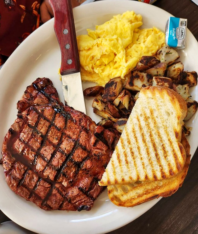 This steak and eggs plate doesn't just break fasts—it shatters expectations with a perfectly grilled ribeye and golden scrambled eggs.