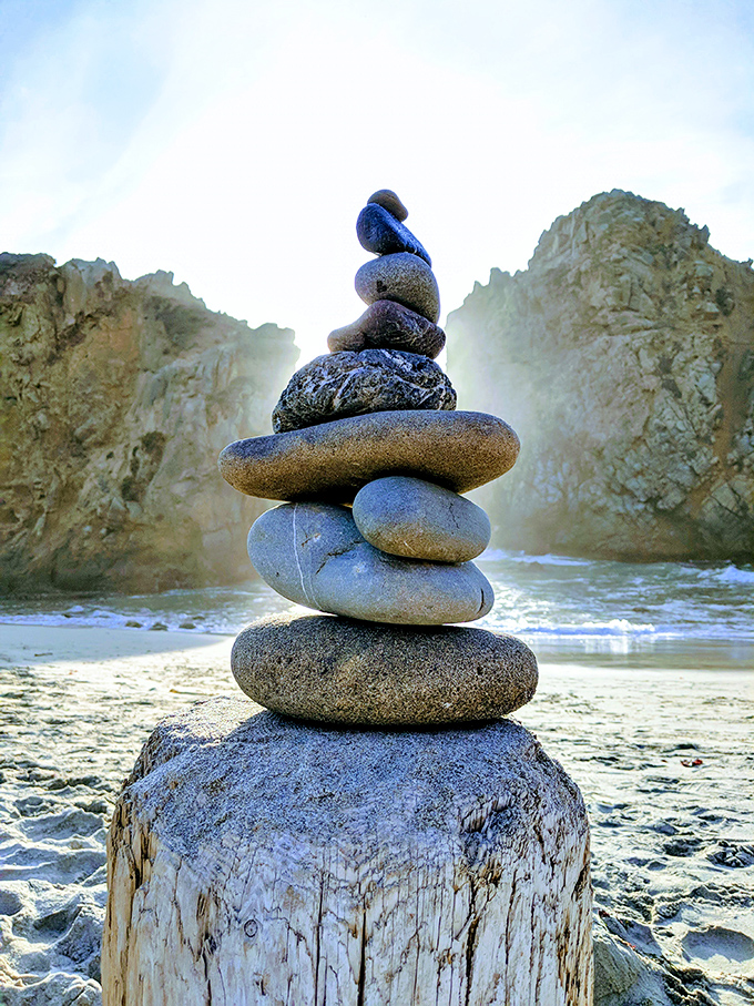 Visitors leave their mark with carefully balanced rock cairns, creating temporary sculptures against permanent beauty.