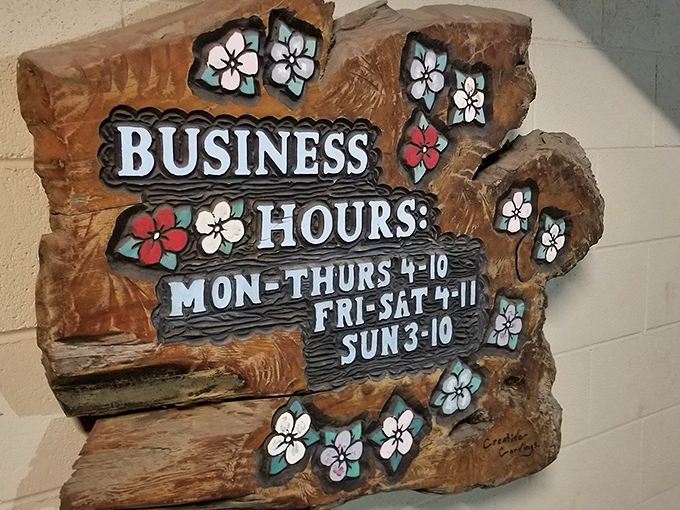 Business hours carved in wood with flower accents&mdash;somehow perfectly capturing The Broiler's blend of no-nonsense food with unexpected charm.