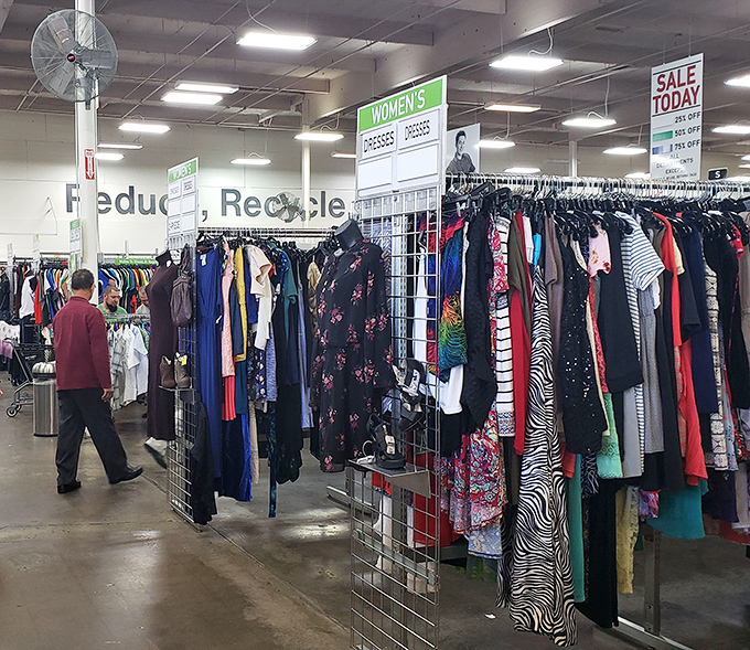 Shoppers navigate the well-organized women's section, where today's "Sale" sign promises even deeper discounts on already thrifty finds.