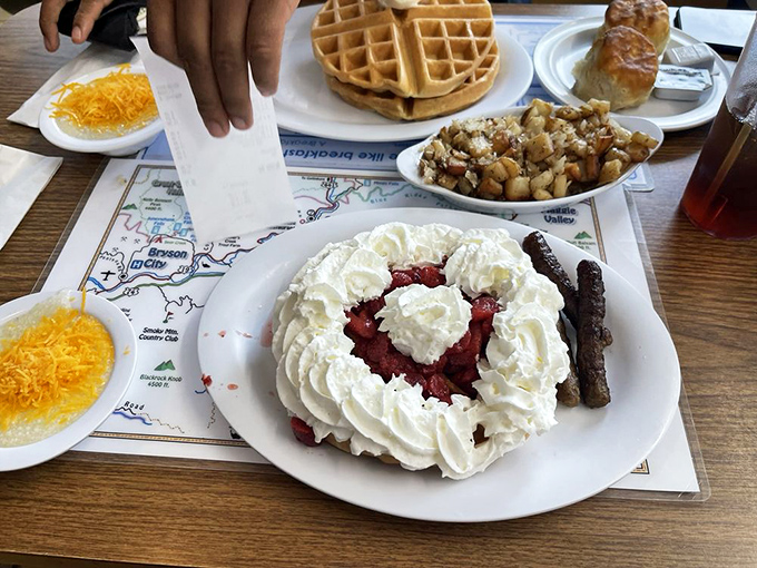A waffle island in a sea of whipped cream with a strawberry heart. This isn't just breakfast; it's dessert with permission to eat it before 10 AM.