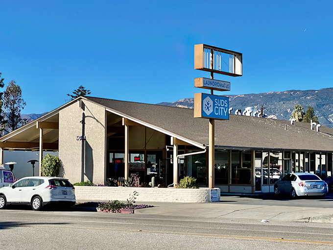 Suds City stands as a monument to mid-century commercial architecture, when even laundromats had personality and mountains served as backdrops.
