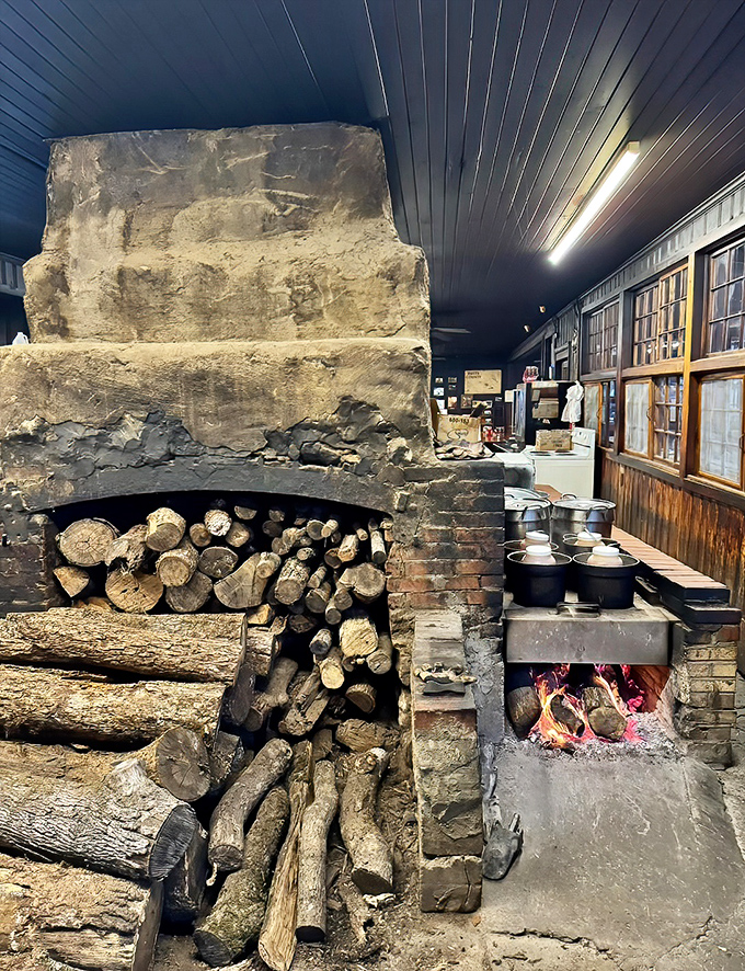 The ancient brick pit and stacked hickory logs reveal barbecue's primal roots – fire, smoke, patience, and the wisdom of generations.