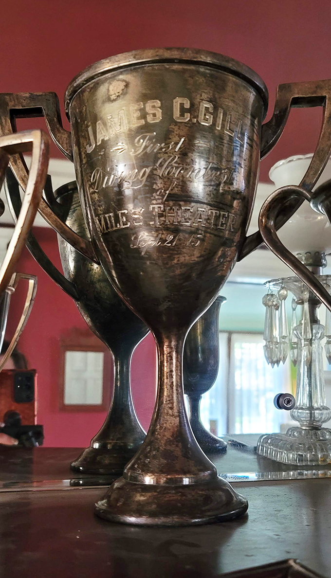 A silver trophy with James C. Gill's name tells of victories long forgotten but still proudly displayed, connecting past achievements to present admirers.