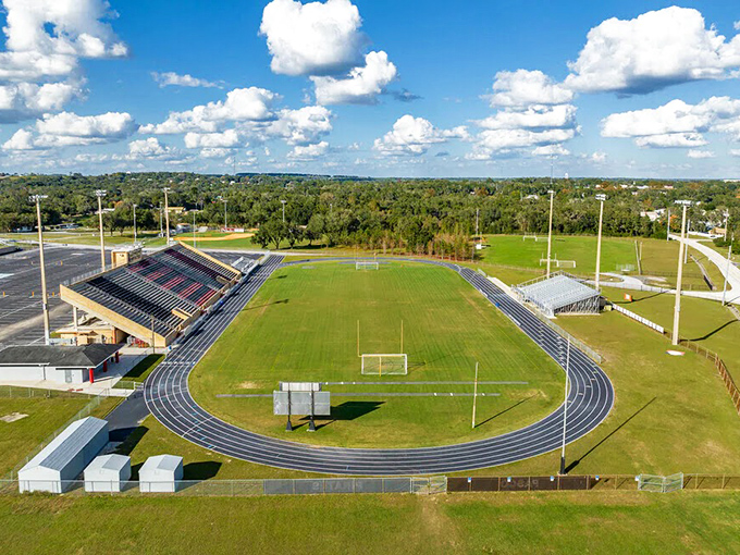 The local stadium stands ready for Friday night lights, where community still gathers to cheer for kids they actually know.