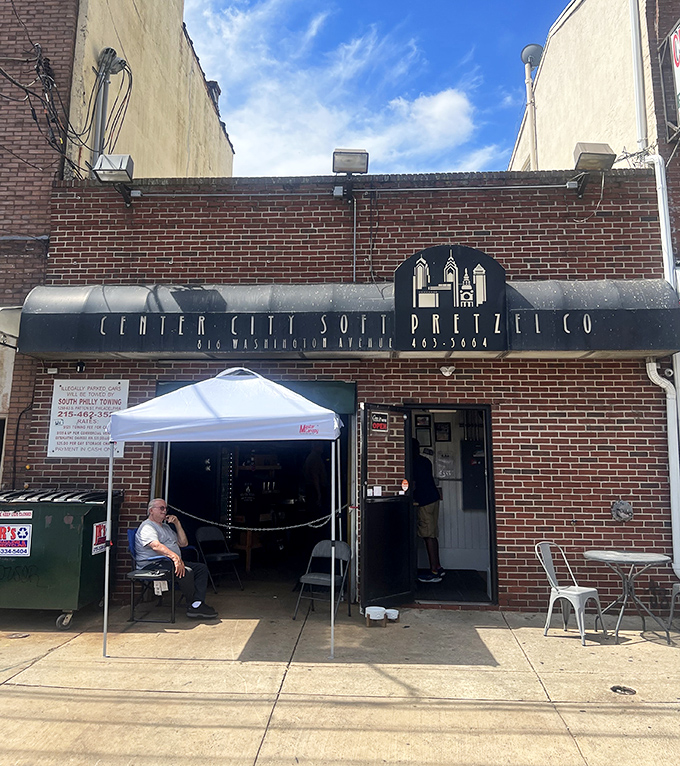 A humble sidewalk setup where pretzel pilgrims gather. In Philadelphia, this isn't just a bakery&mdash;it's a community gathering spot.