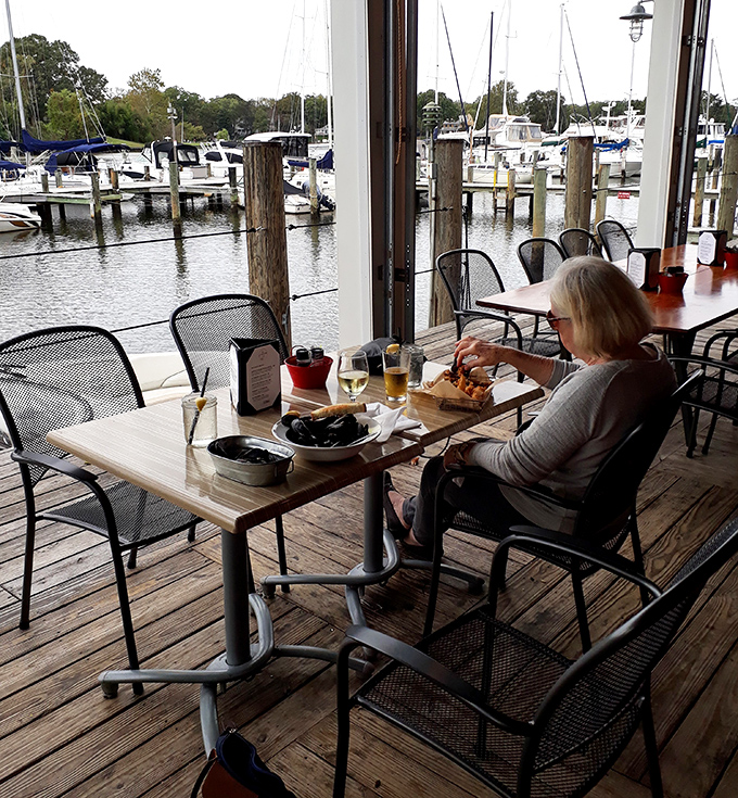 Dining with a front-row seat to boat life. This woman knows the secret: seafood always tastes better when you can see where it came from.