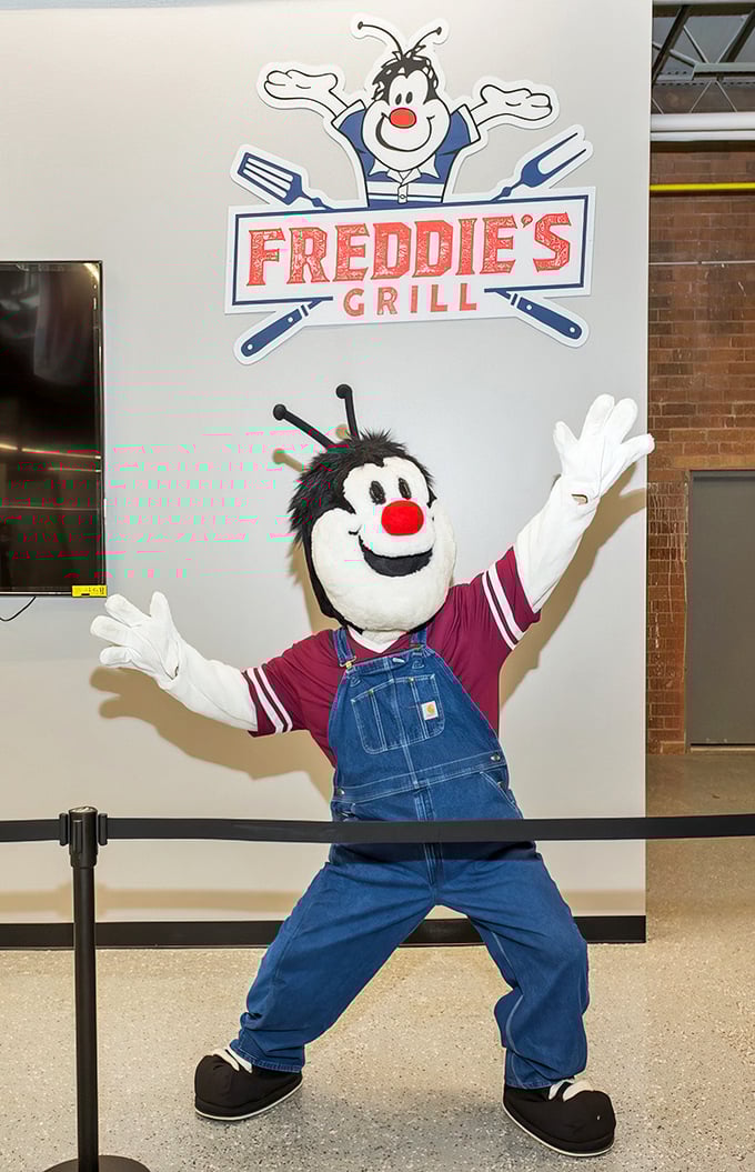 Freddie's Grill mascot welcomes hungry shoppers with open arms, promising comfort food that fuels the next round of bargain hunting.
