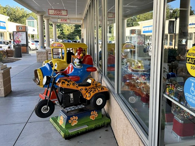Kiddie rides providing entertainment while parents recover from the shock of actually affordable designer shopping spree victories.