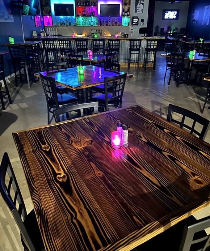 When the sun sets, Legends transforms into a neon-lit sanctuary for night owls. The wooden tables glow with possibility under colorful lights.
