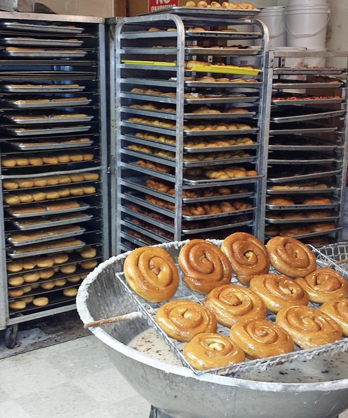 Fresh cinnamon rolls emerging from their glazed bath, looking like they just got back from the spa.