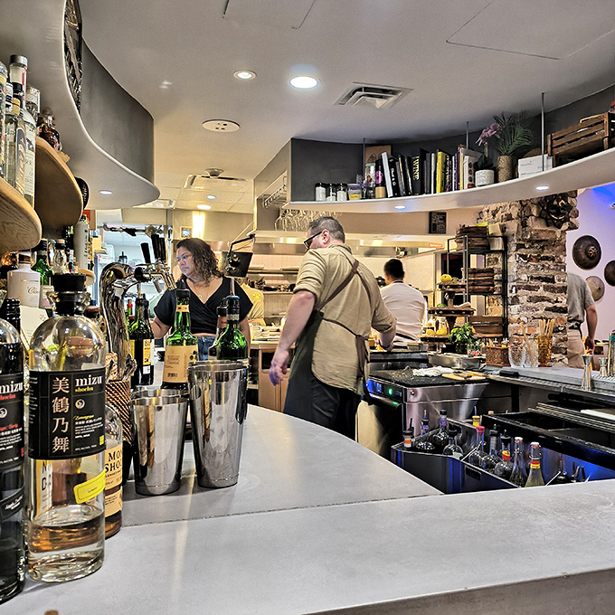 "Behind the bar, bottles stand at attention like soldiers ready to enhance your Filipino feast. Mixology meets tradition in every pour."