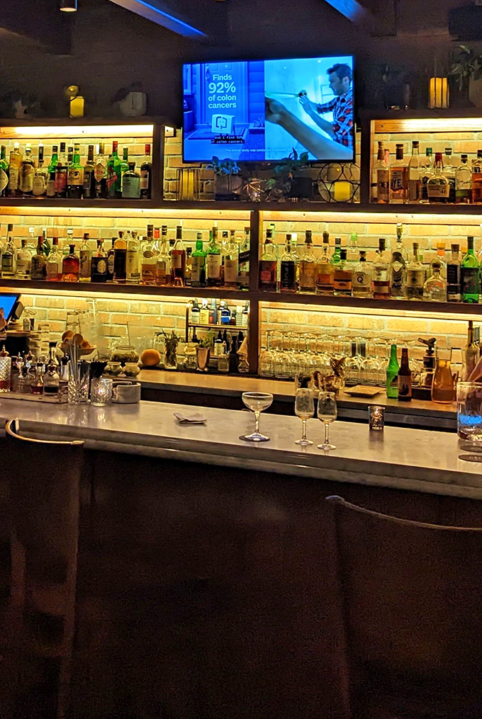 The bar's illuminated shelves showcase bottles like museum artifacts, each promising a different journey through Italy's wine regions.