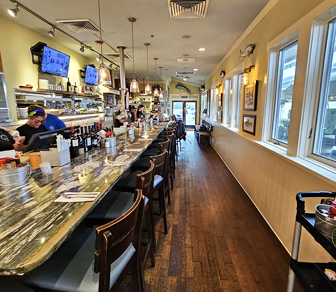 The bar area stretches invitingly, offering front-row seats to both the bartender's craft and the kitchen's culinary choreography.