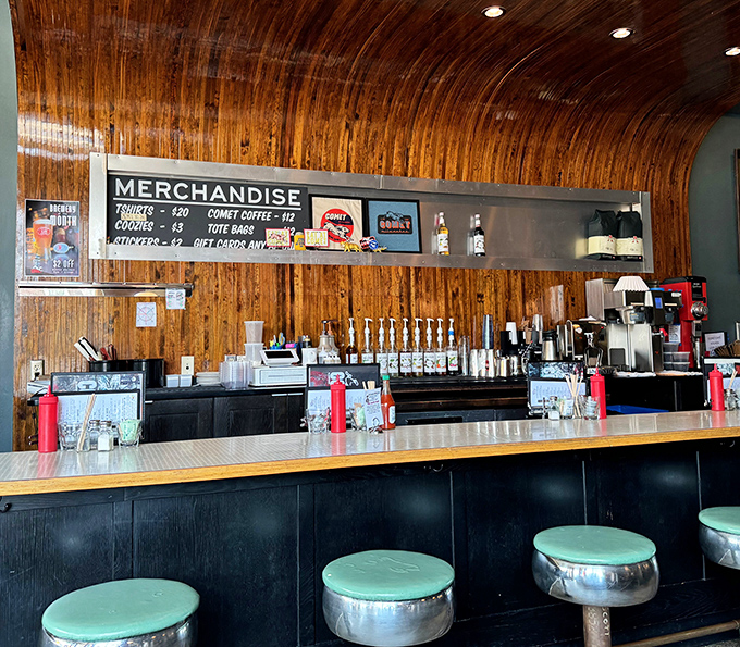 The bar's wooden paneling and merchandise display channel a mid-century rec room vibe. Those mint green stools have supported countless happy customers.