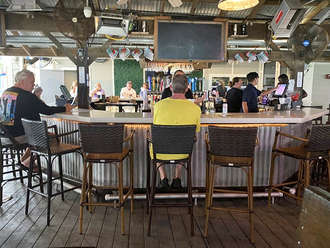 The bar's corrugated metal and weathered wood feels like the perfect coastal hideaway—where strangers become friends over cold drafts and fish tales.