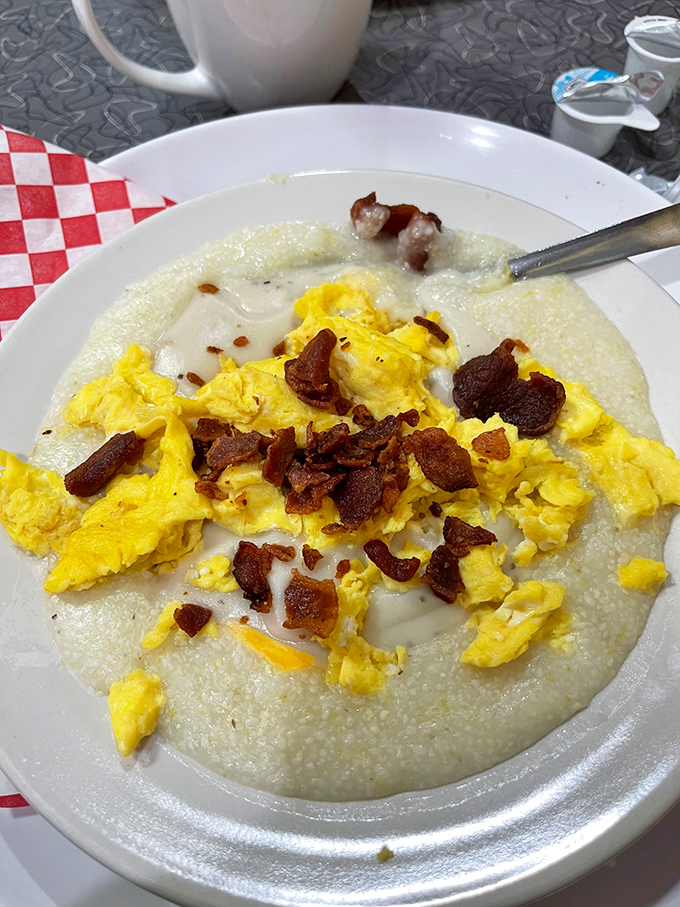 Grits topped with scrambled eggs and bacon bits &ndash; a Southern breakfast trinity that proves simplicity is often the highest form of culinary art.