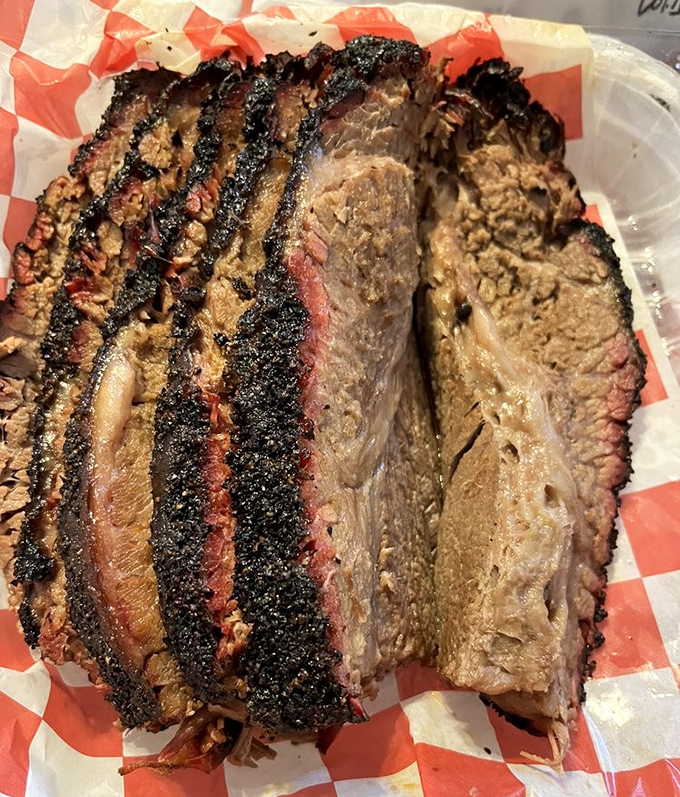 Brisket sliced so perfectly it could make a grown Texan weep. That smoke ring isn't just good&mdash;it's frame-worthy.