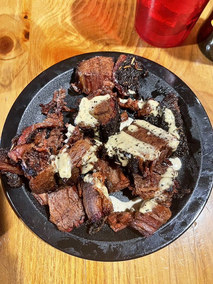 Burnt ends – those caramelized, twice-smoked brisket morsels – drizzled with sauce that makes you question why you've wasted time eating anything else.