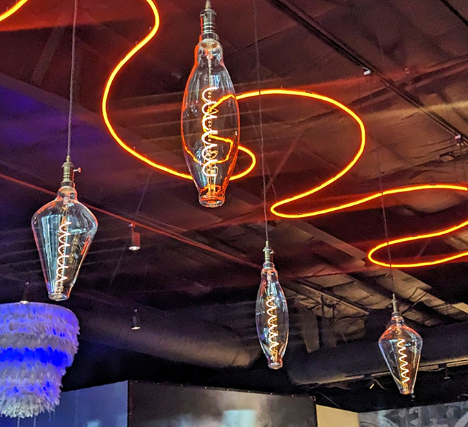 Edison bulbs dance above like illuminated jellyfish, adding whimsy to the sophisticated atmosphere below.
