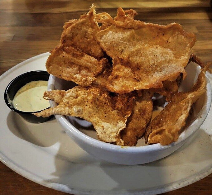 Chicken skins that have achieved their highest purpose: becoming perfectly crispy vessels for dipping sauce. Potato chips just got seriously outclassed.