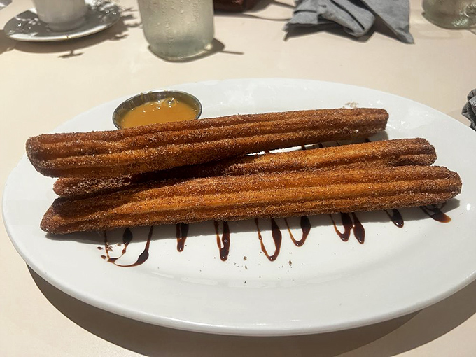Those churros arrive dressed in cinnamon-sugar armor, ready to battle your dessert expectations and win decisively.