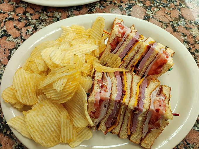 A club sandwich that requires jaw exercises before attempting. Those layers tell a better story than most bestselling novels.
