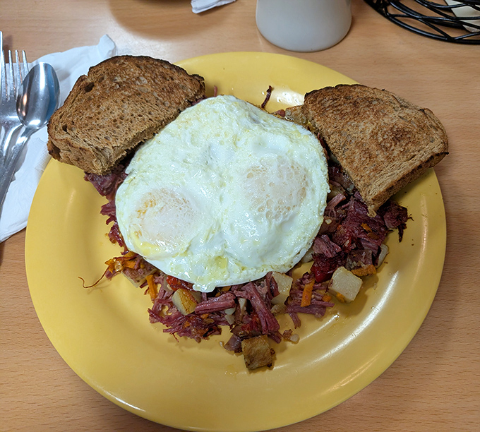 Corned beef hash crowned with eggs that could solve international conflicts. The toast stands by, ready to soak up any diplomatic negotiations.