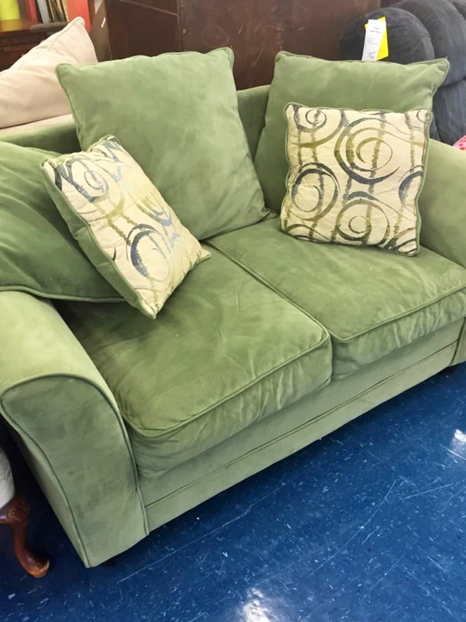 This mint green loveseat isn't just furniture—it's the future centerpiece of someone's first apartment, complete with stories we'll never know.