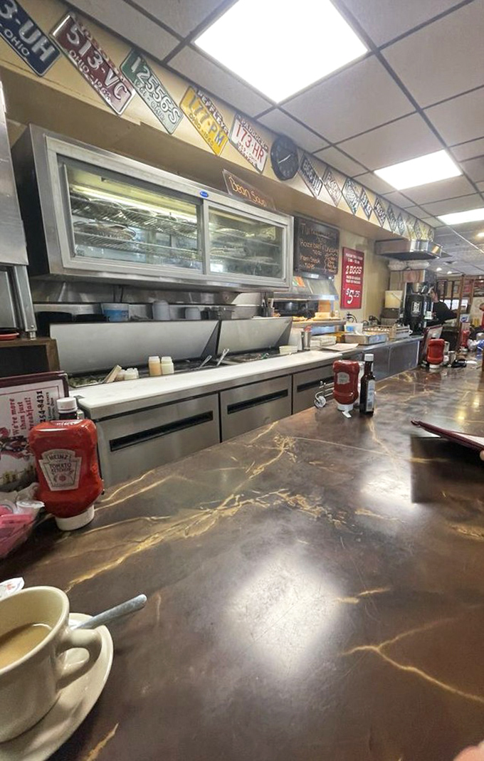 The counter where breakfast magic happens, with license plates above telling stories of places traveled and meals remembered.
