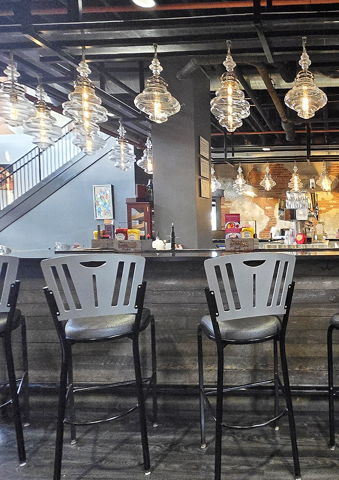 Those distinctive metal chairs aren't just seating&mdash;they're front-row tickets to the culinary show happening behind that well-stocked bar.