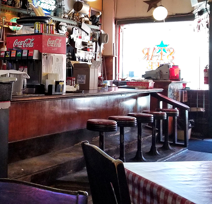 The counter seating offers front-row tickets to the culinary show, complete with vintage Coca-Cola dispensers and the comforting rhythm of short-order cooking.