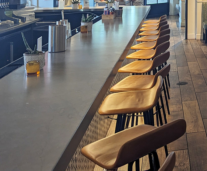 Counter seating offers front-row views of culinary artistry while maintaining that approachable neighborhood restaurant vibe.