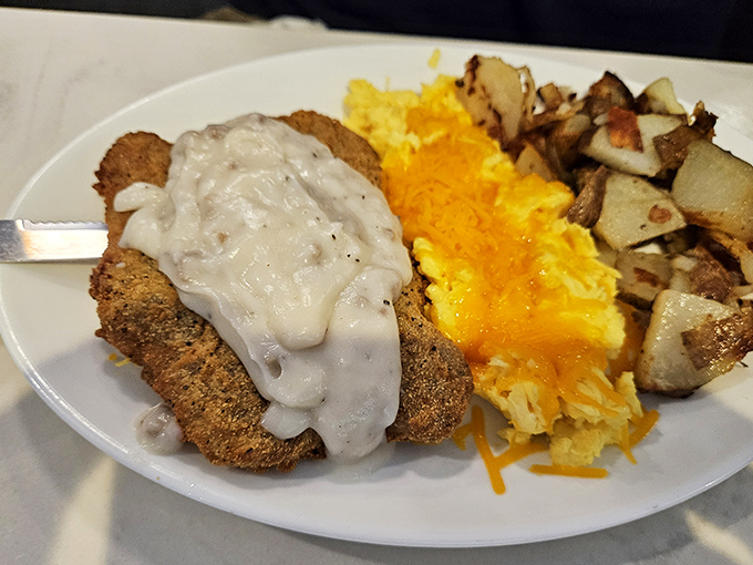 Country fried steak smothered in gravy that could make a vegetarian question their life choices, alongside eggs and potatoes that refuse to be upstaged.