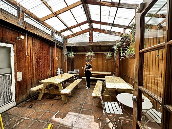 The covered patio offers a perfect California dining experience&mdash;casual wooden benches under a translucent roof that captures natural light.