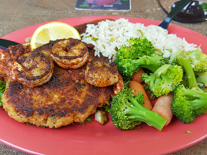This crab cake doesn't just sit on the plate&mdash;it commands attention, flanked by perfectly blackened shrimp and colorful vegetables.