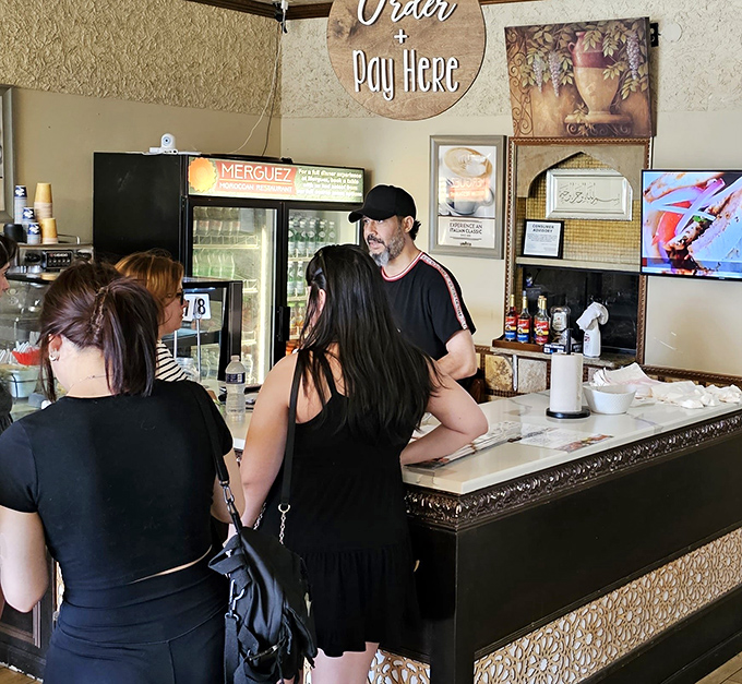 The ordering counter becomes a gathering spot where hungry patrons eagerly await their turn to embark on a Moroccan culinary adventure.