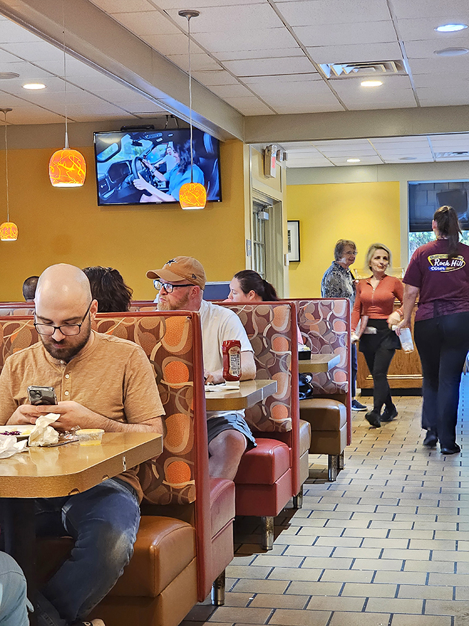 The true measure of a great diner: diverse patrons in comfortable booths, each experiencing their own personal moment of food bliss.