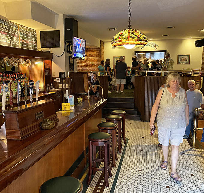Happy diners enjoying Plymouth's famous hospitality in the warmly lit dining room with brick accent walls.