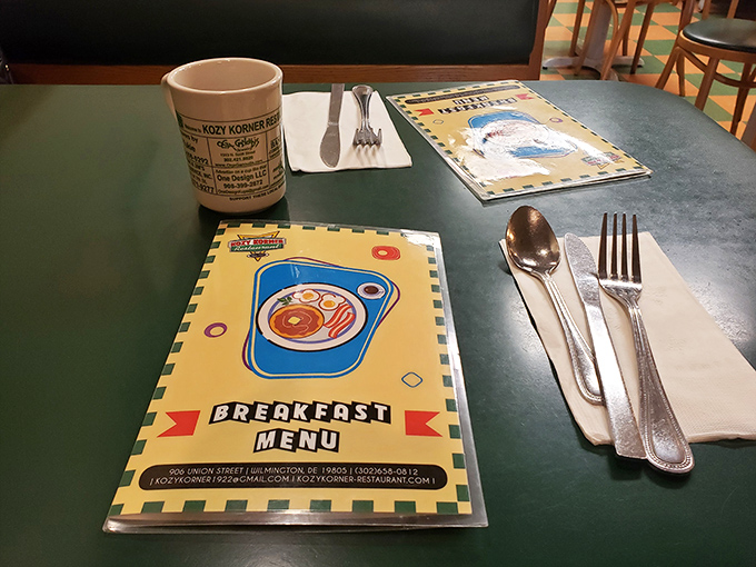 The simple place setting awaits your order. That menu cover art says everything about Kozy Korner's unpretentious charm.
