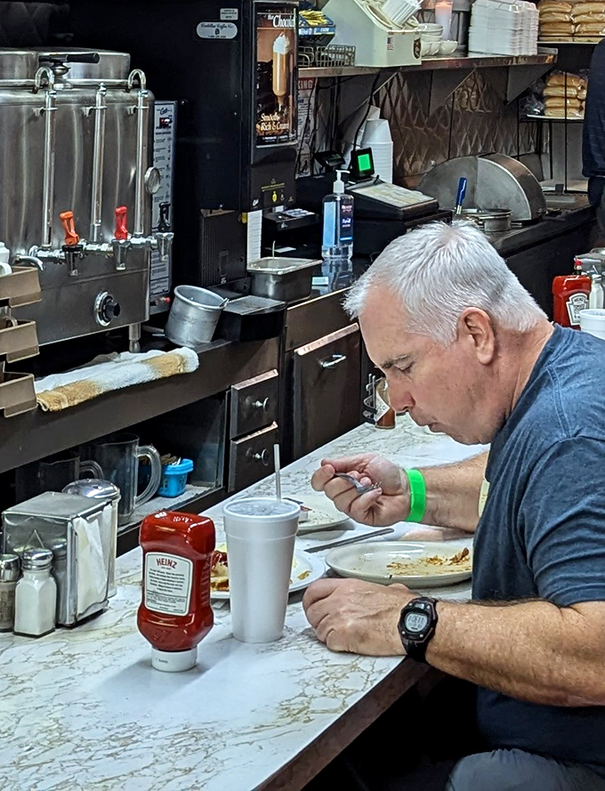 The coffee station&mdash;where the elixir of life flows freely into those thick white mugs that somehow make coffee taste better than any fancy ceramic ever could.