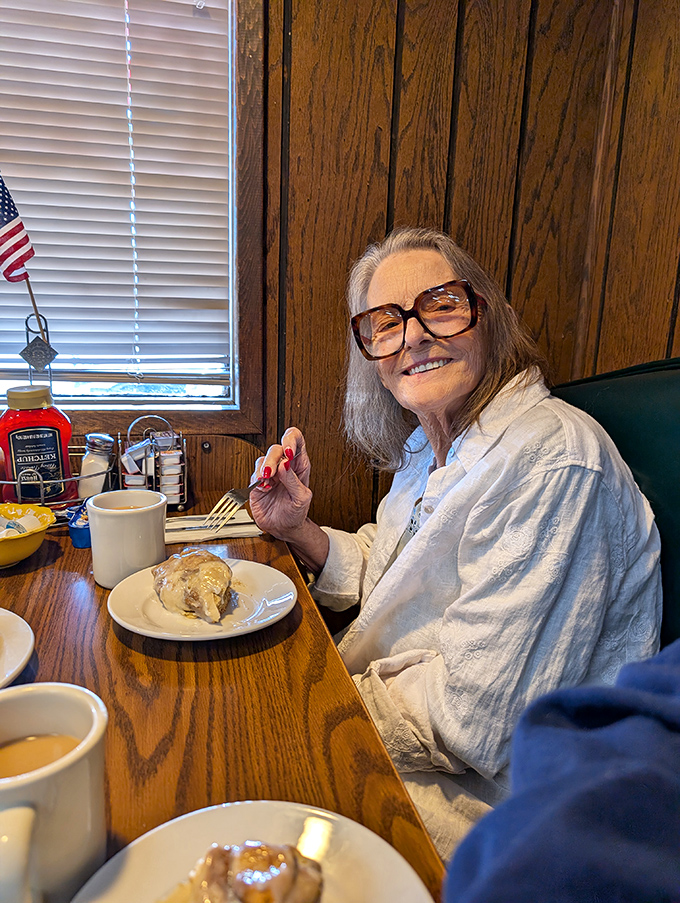 A happy diner enjoying her meal&mdash;the universal expression that says "I've found my happy place, and it comes with hash browns."
