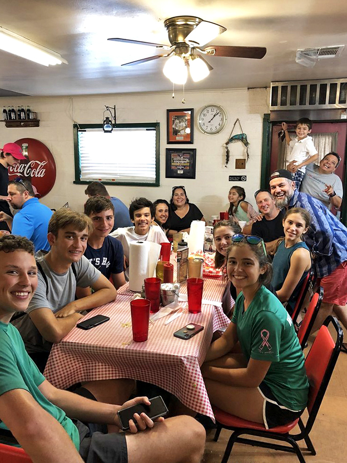 A dining room filled with happy patrons proves that Mel's isn't just serving food - it's creating memories around red-checkered tables.