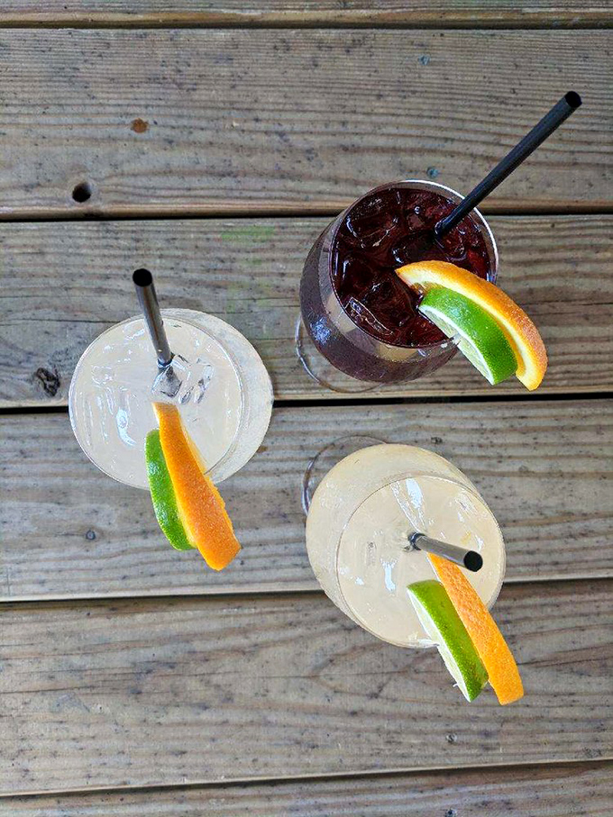 Cocktails arranged like old friends catching up. That citrus garnish isn't just decoration&mdash;it's an exclamation point on liquid happiness.