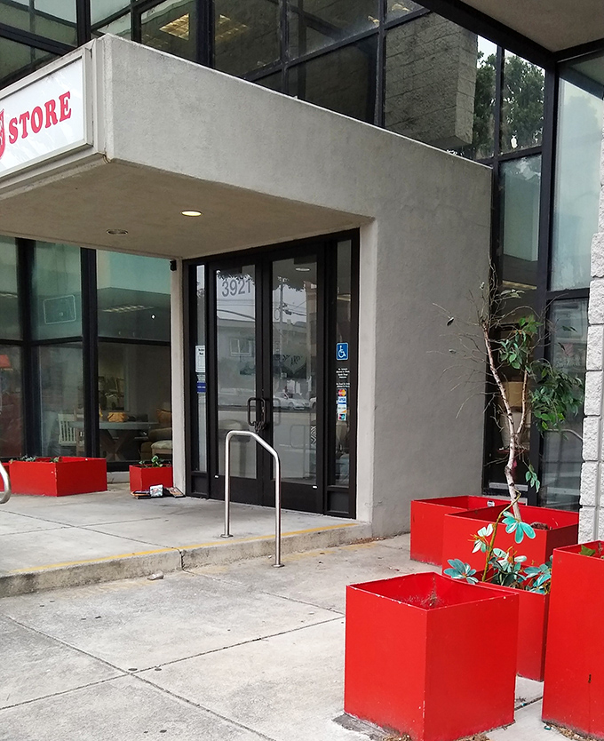 The entrance's red planters add a pop of color to the concrete exterior &ndash; a cheerful welcome to bargain hunters and donation-droppers alike.