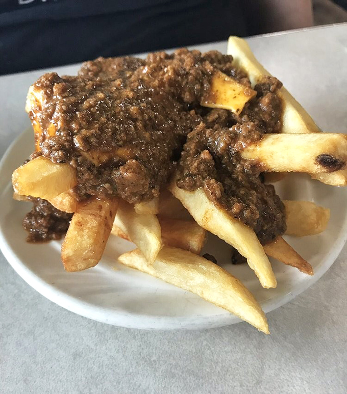 Greek-style chili fries that don't mess around. This hearty plate of hand-cut potatoes smothered in seasoned meat sauce is what comfort food dreams are made of.