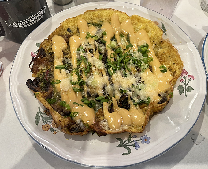 This isn't just an omelet; it's a flavor explosion draped in sauce that makes you question why all breakfasts can't be this exciting.