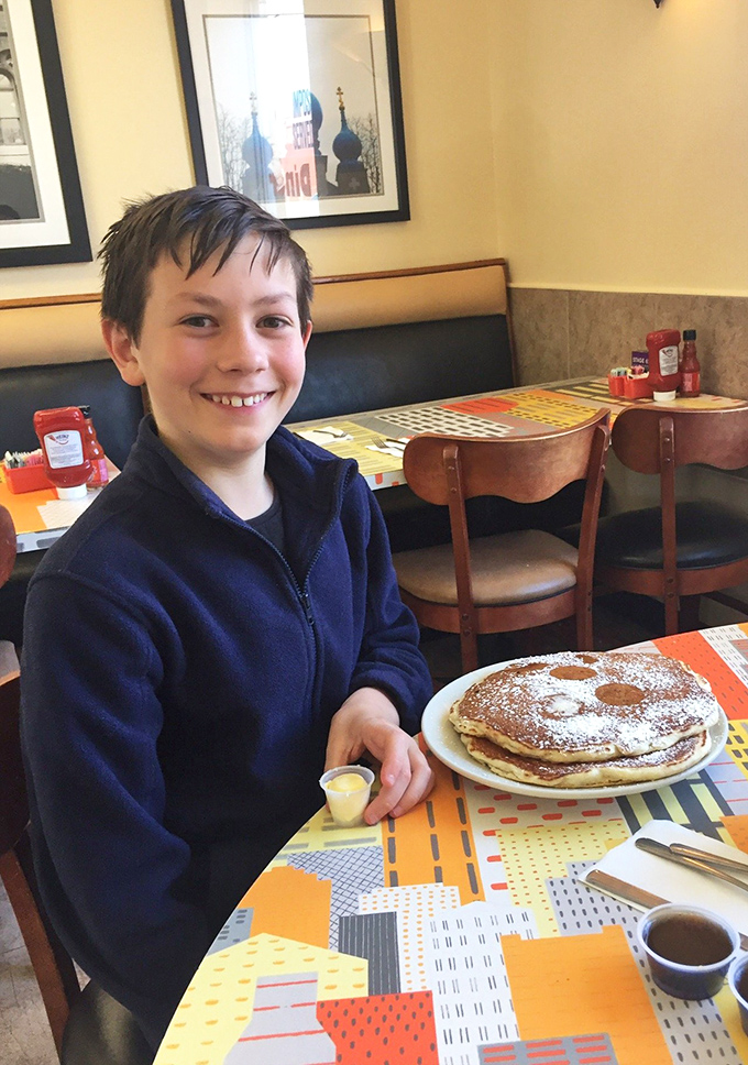 The universal expression of pancake joy &ndash; powdered sugar dusted flapjacks that make smartphones temporarily irrelevant.